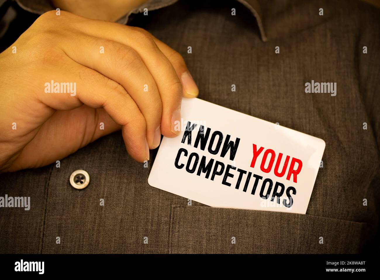 Businessman putting a card with text know your competitors in the ...