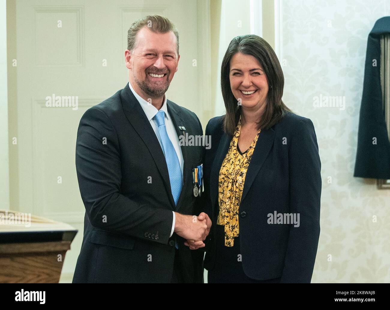 Mike Ellis shakes hands with Alberta Premier Danielle Smith after being ...