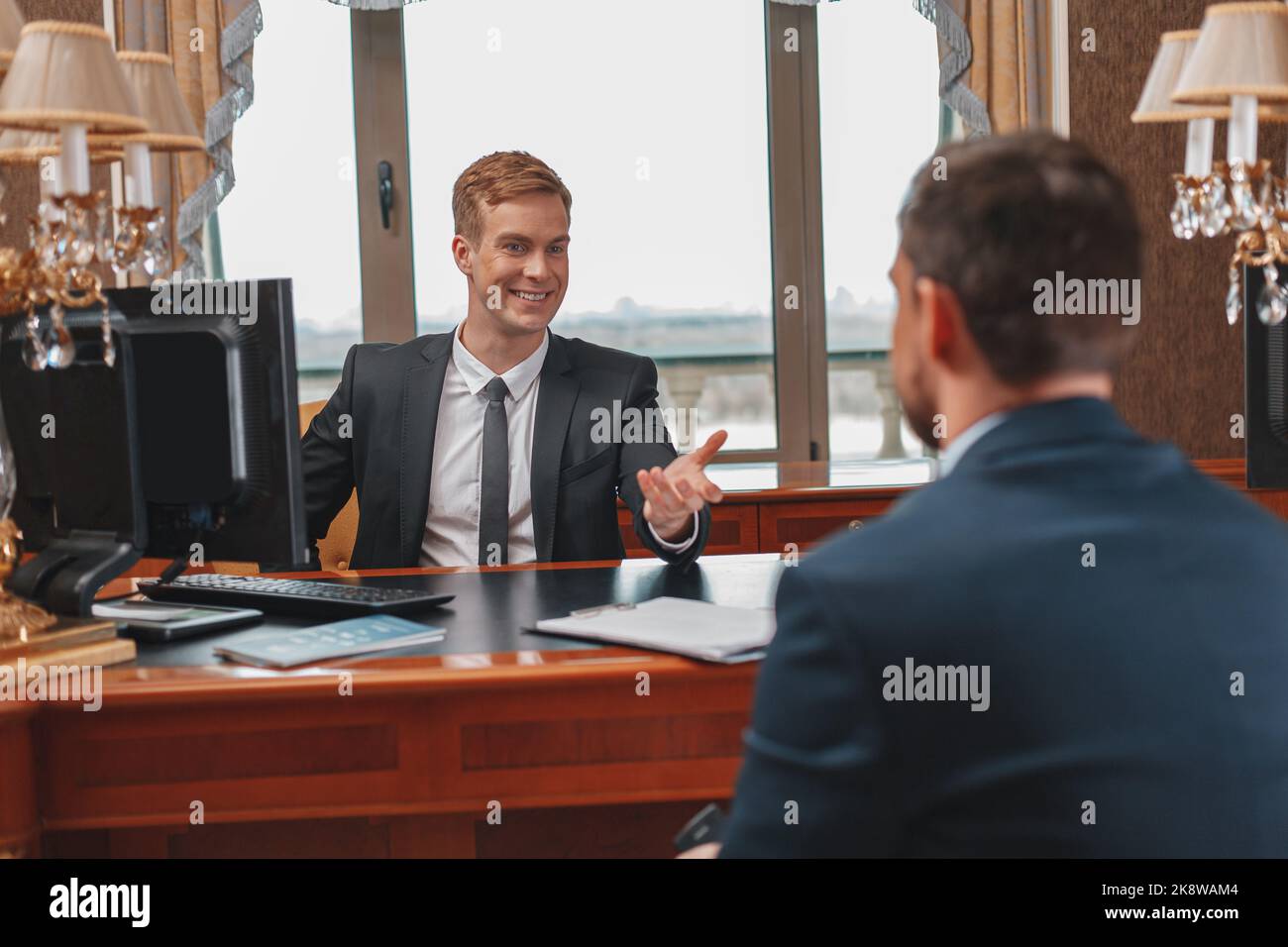 Smiling hotel receptionist helping Businessman to check in and receive ...