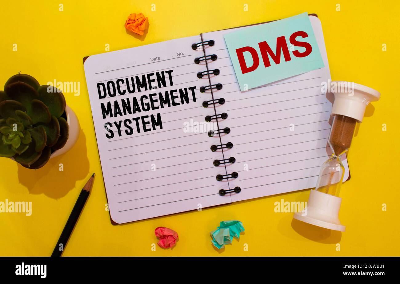 White office desk table with blank sheet , text DMS Document Management ...