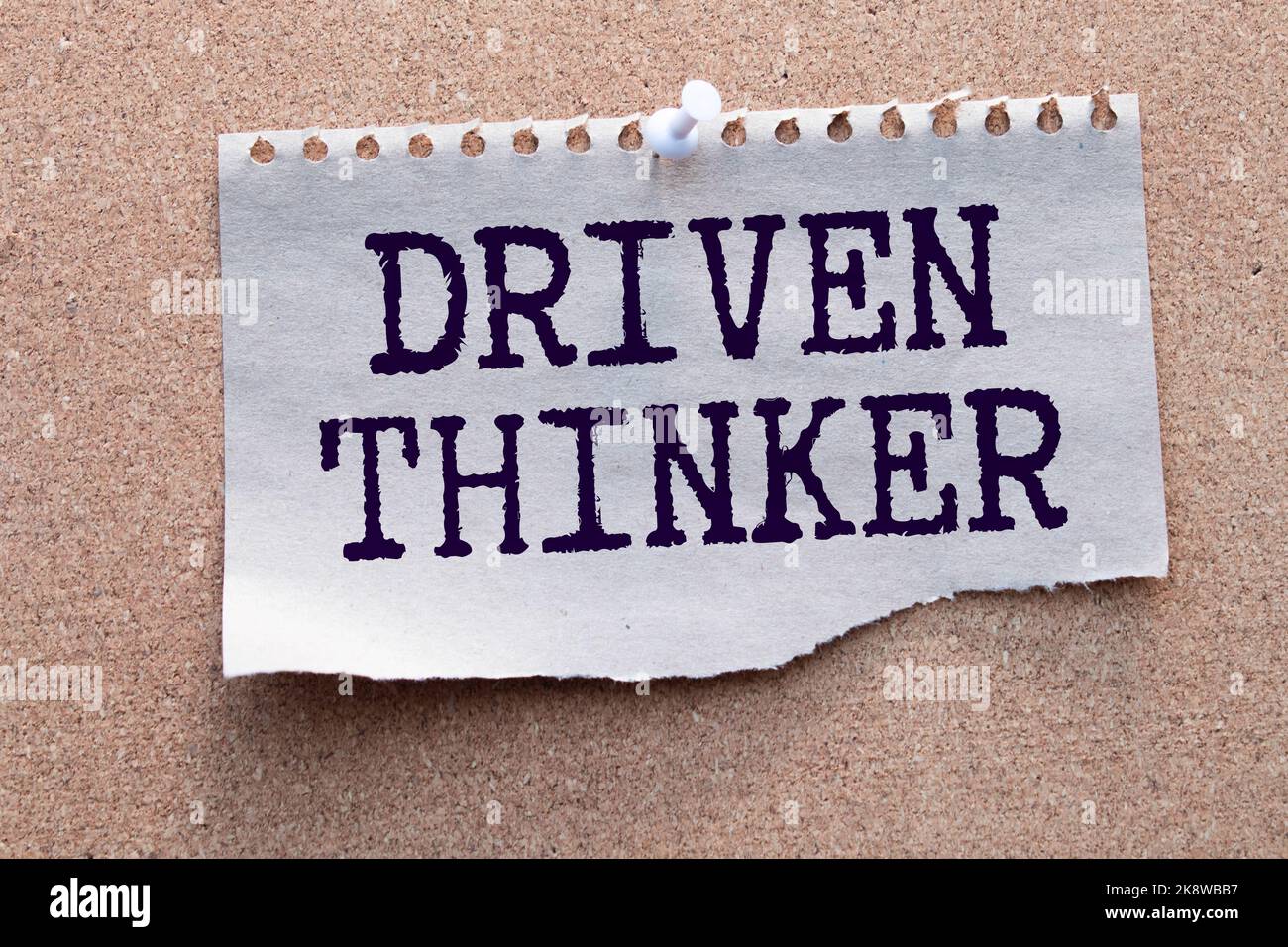 Closeup on businessman holding a card with text DRIVEN THINKER ...