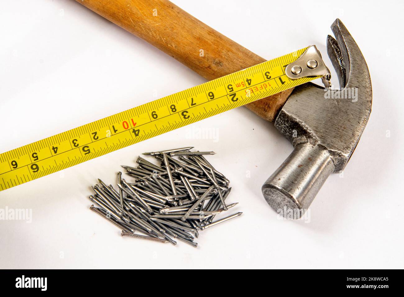 yellow tape measure and hammer im white background Stock Photo - Alamy