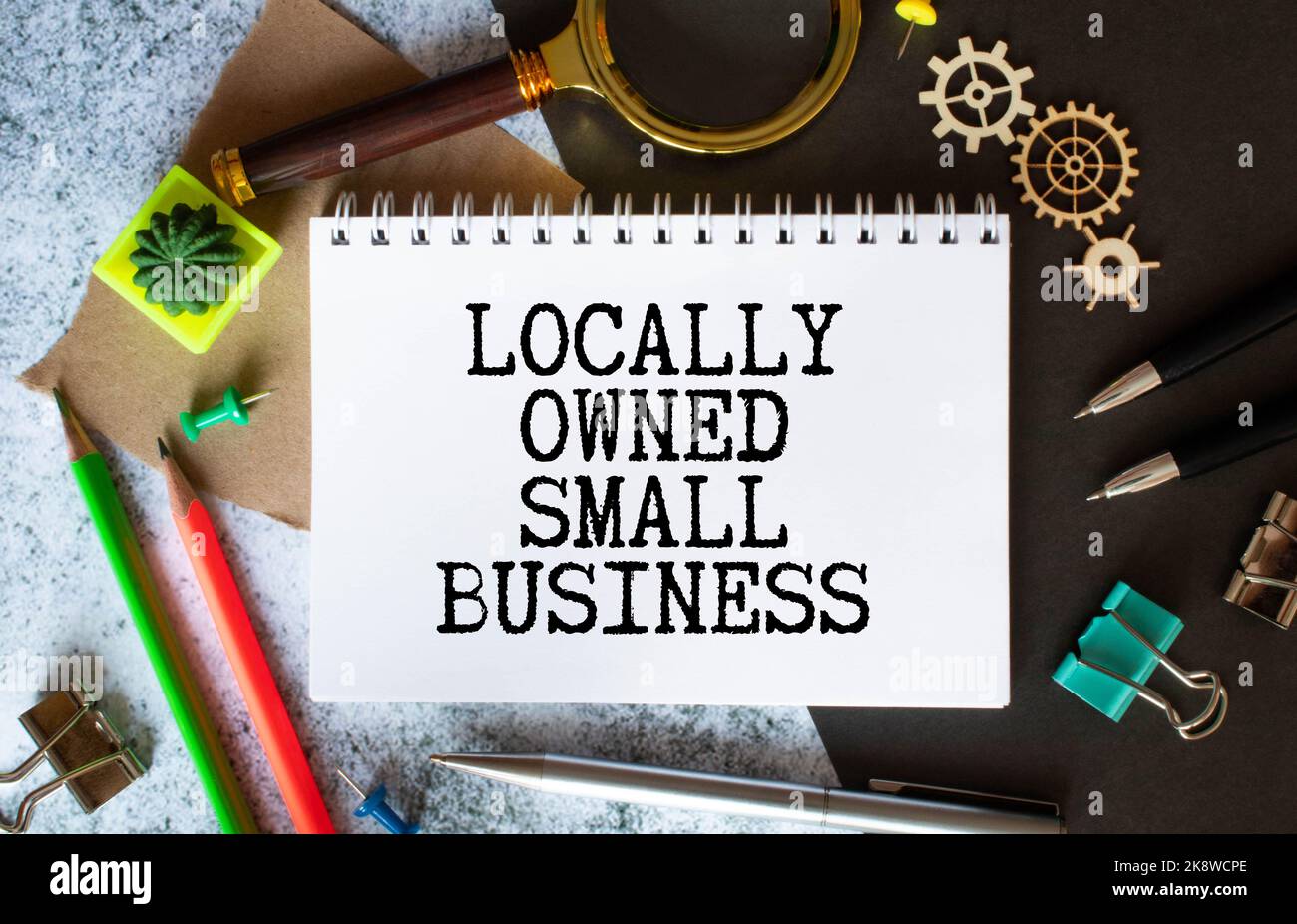 Closeup on businessman holding a card with text LOCALLY OWNED SMALL ...