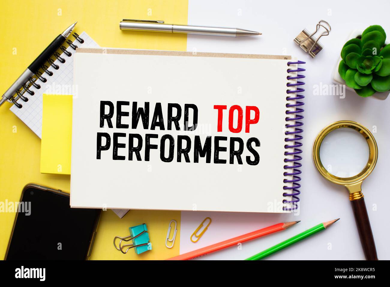 Reward top performers text memo written on a white background with ...