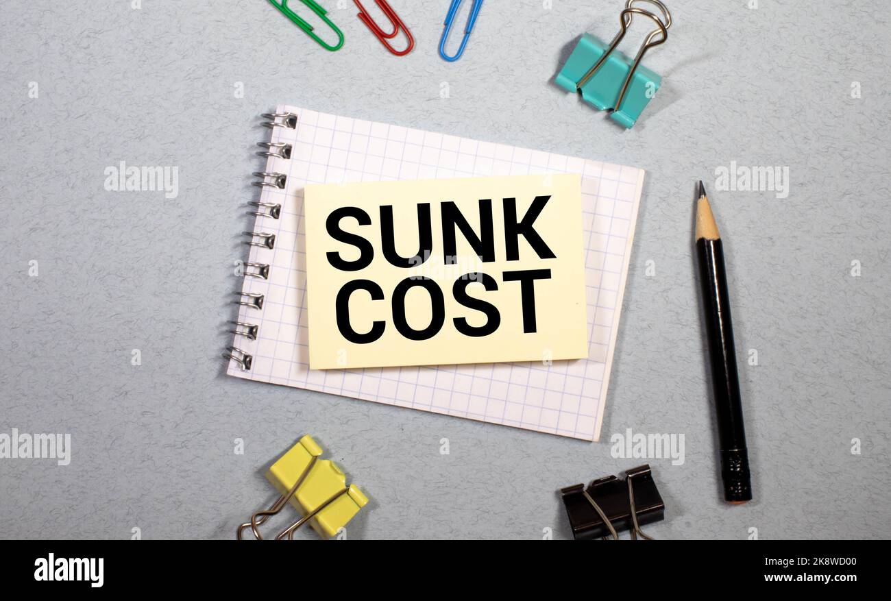 Notepad with the text SUNK COST on a white background. And the word ...