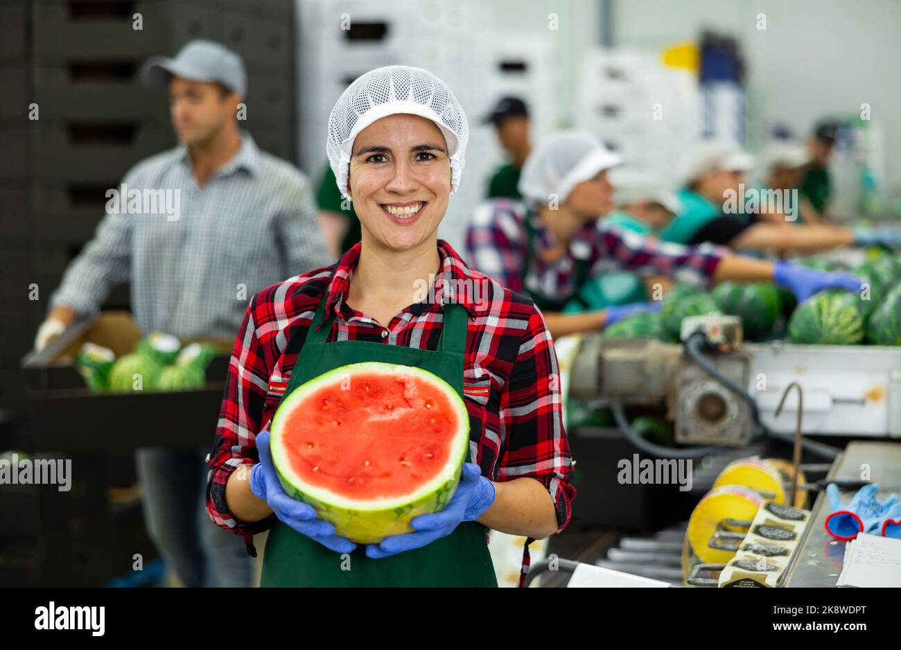 Portrait of pleased woman with half of juicy red watermelon while ...
