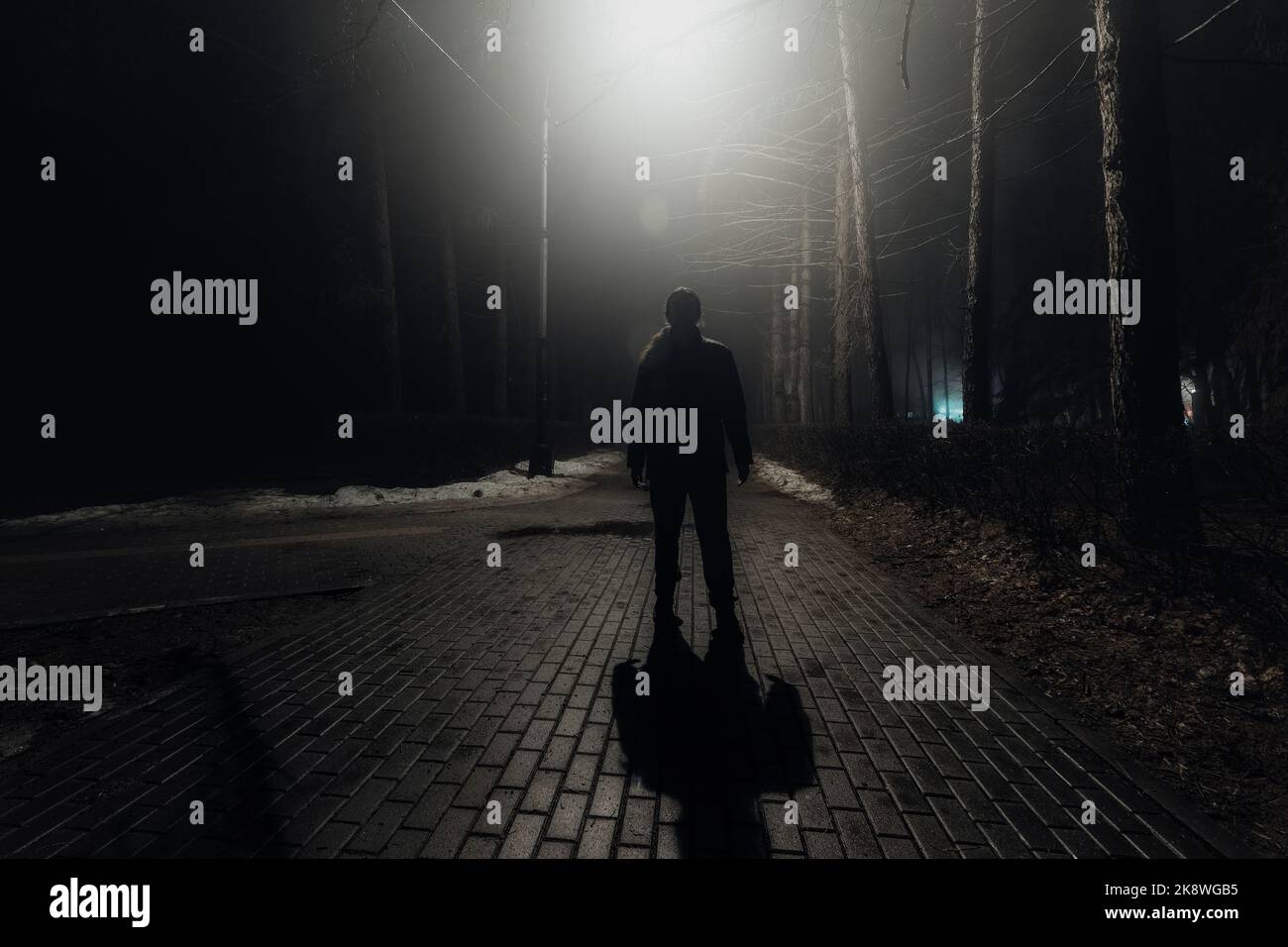 Sad man alone walking along the alley in night foggy park Stock Photo ...