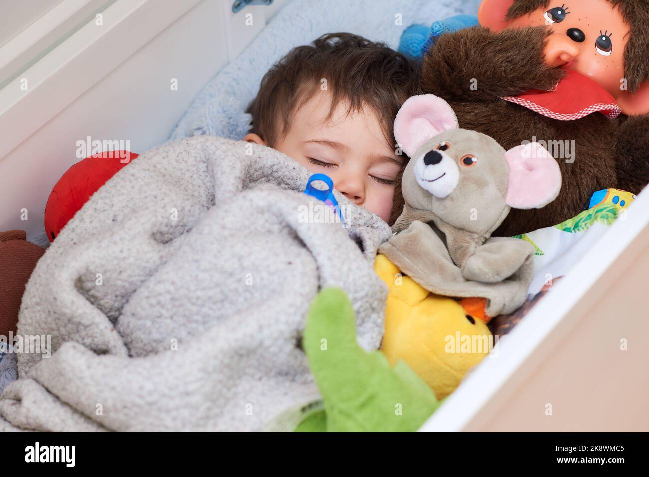 cute baby is sleeping in a box with his toys Stock Photo - Alamy
