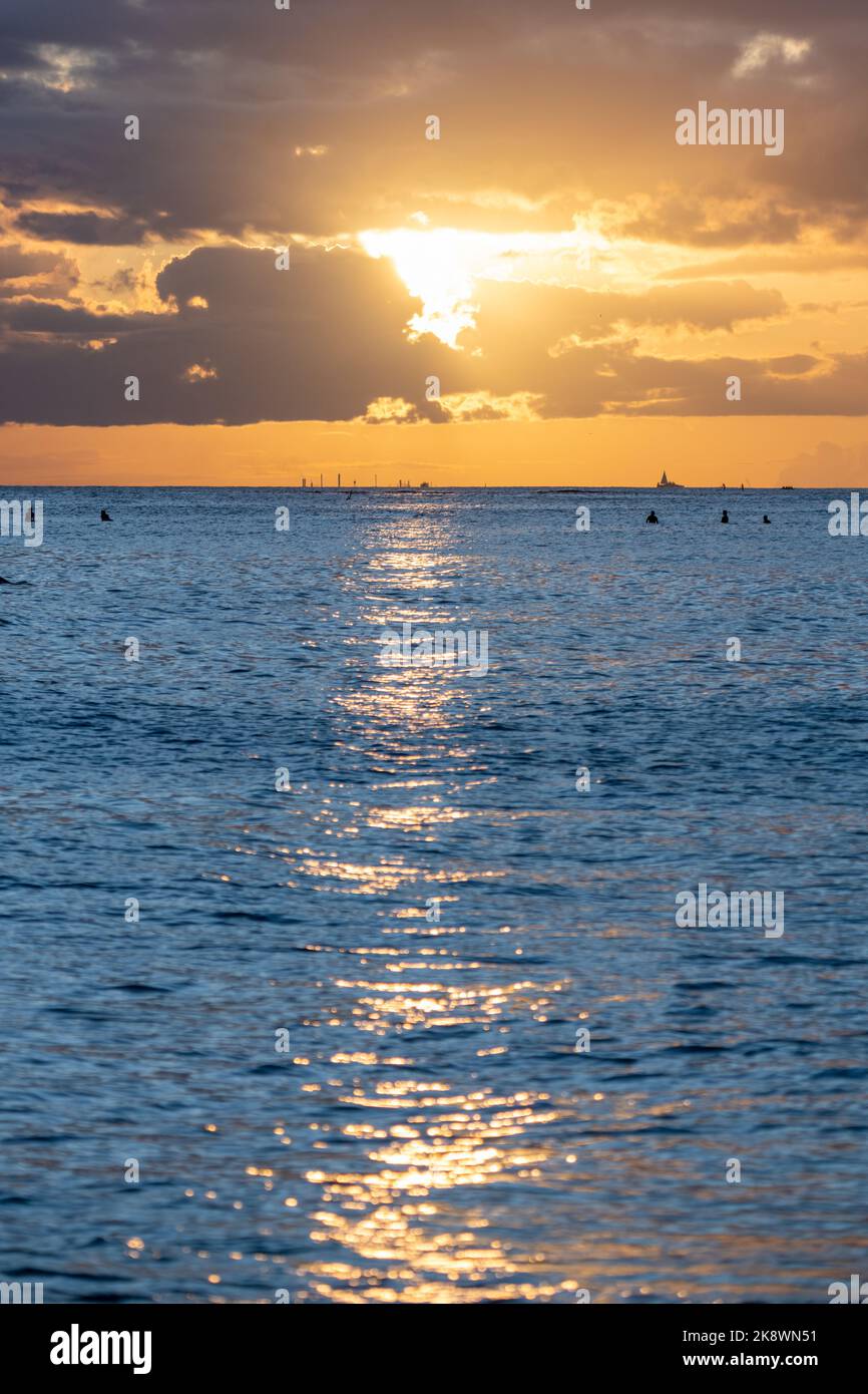 Stunning sunset from Oahu in Hawaii with silhouettes of surfers and ...