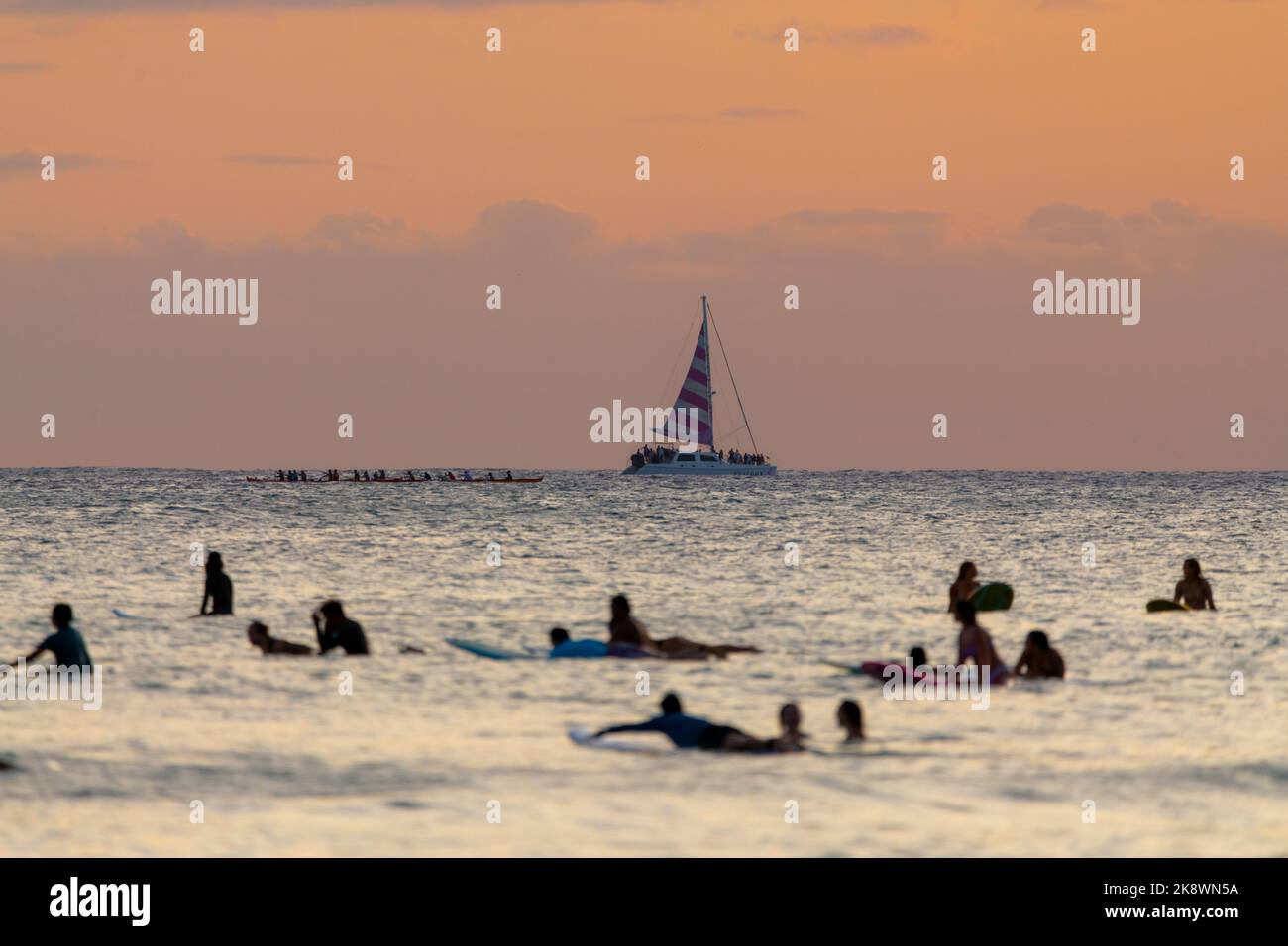 Stunning sunset from Oahu in Hawaii with silhouettes of surfers and ...