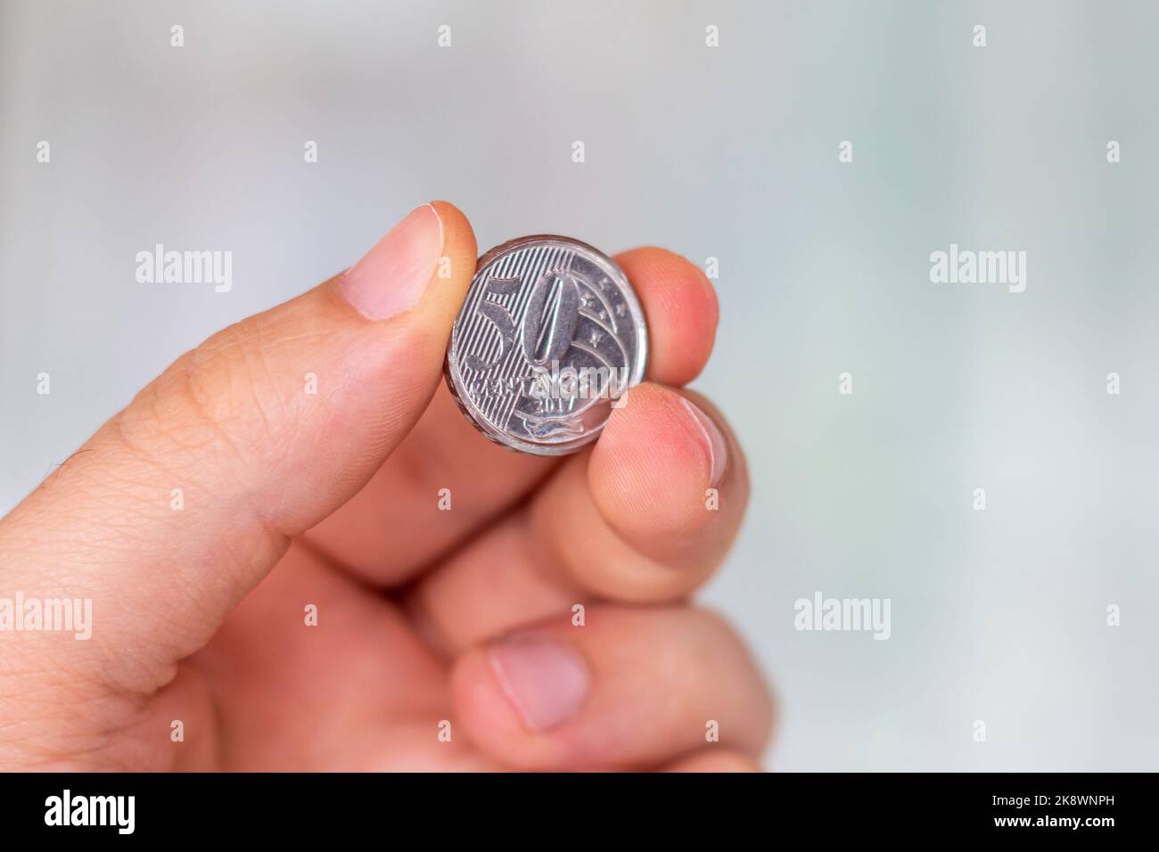 Brazilian 50 cents coin in the palm of a person. Hand holding a 50 real ...