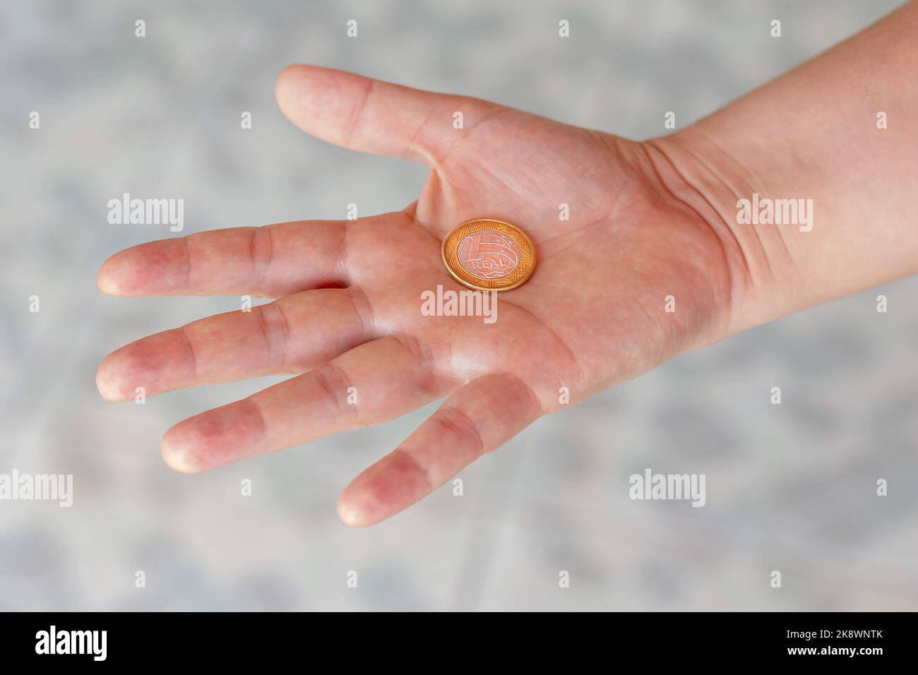 One real coin in the palm of a person's hand. Hand holding a 1 dollar ...