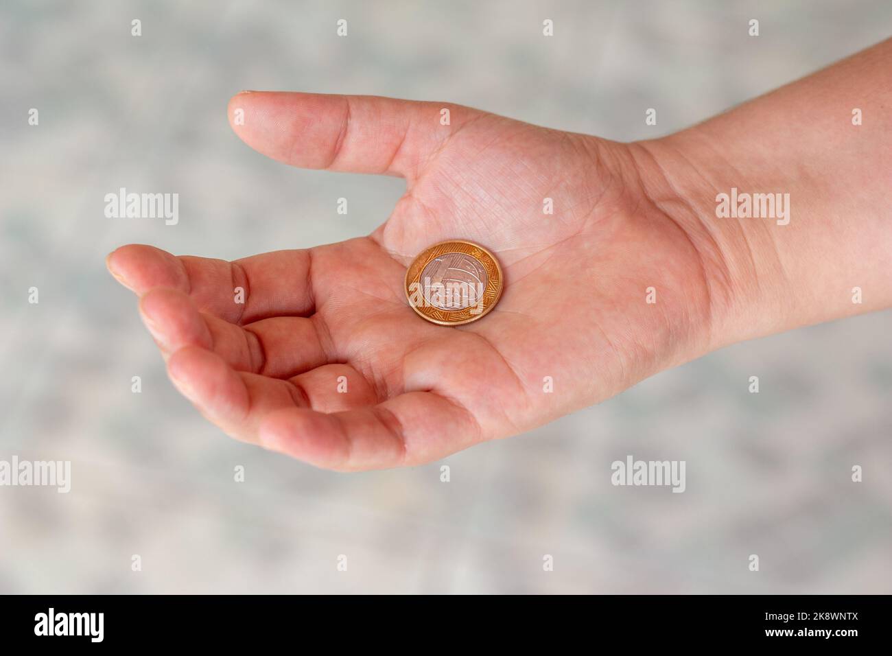 One real coin in the palm of a person's hand. Hand holding a 1 dollar ...