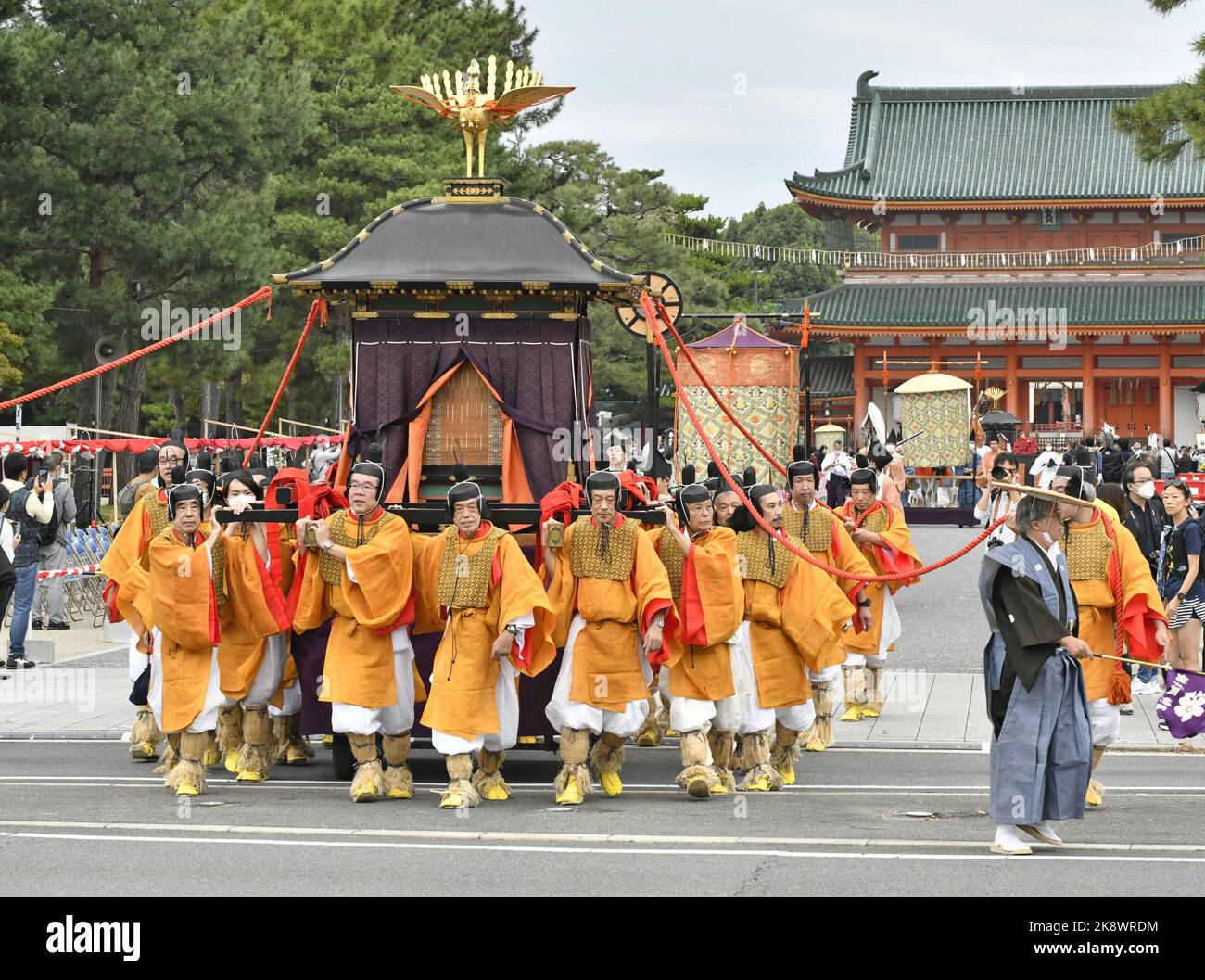 A group of people in ancient costumes carry a portable shrine from ...