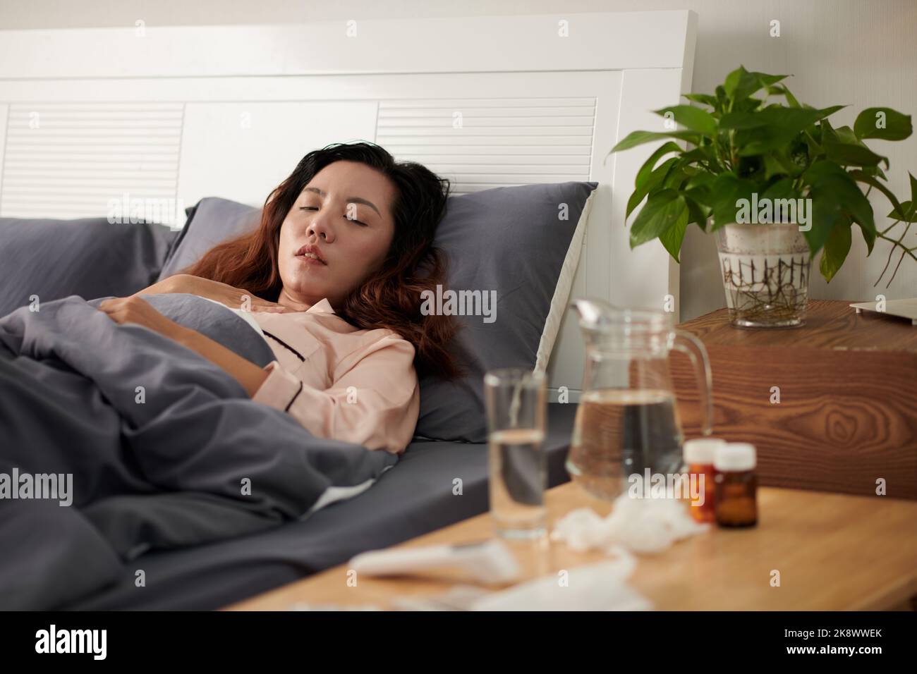 Sick young woman sleeping in bed after taking medicine Stock Photo - Alamy