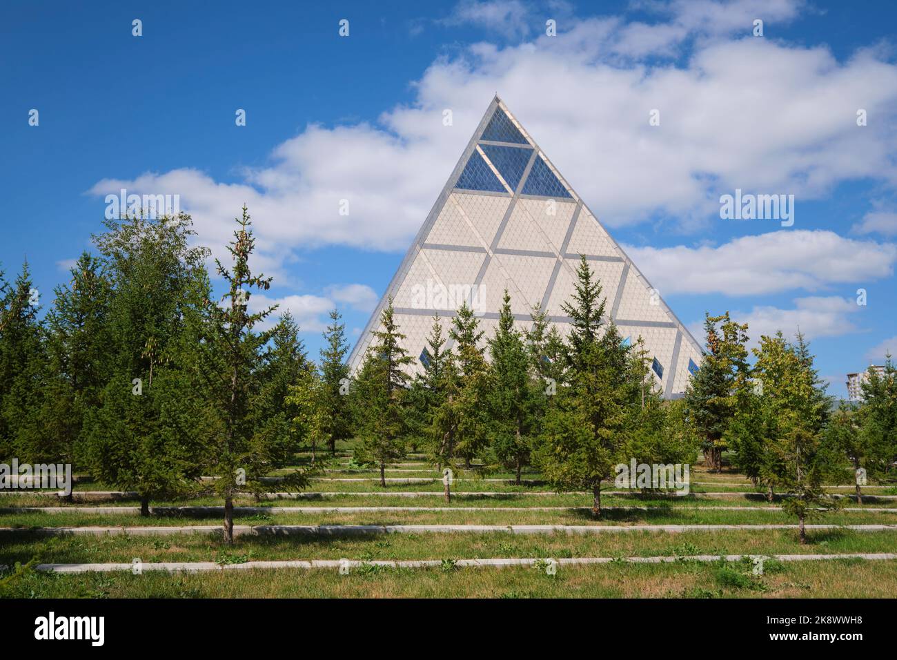 A view of the pyramid with trees and green grass in the foreground. At ...