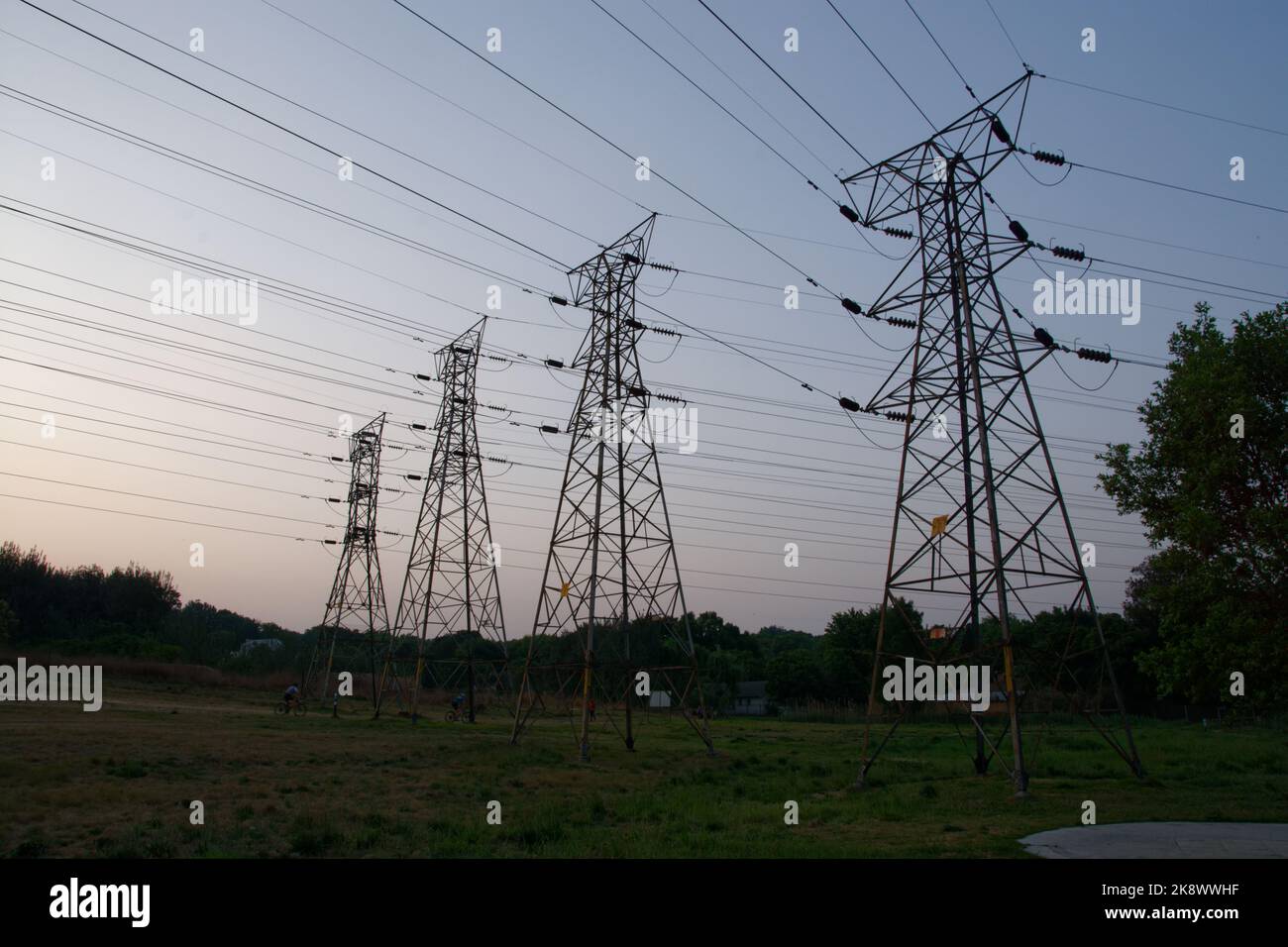 Four Electrical overhead cable Pylons silhouetted against the evening ...