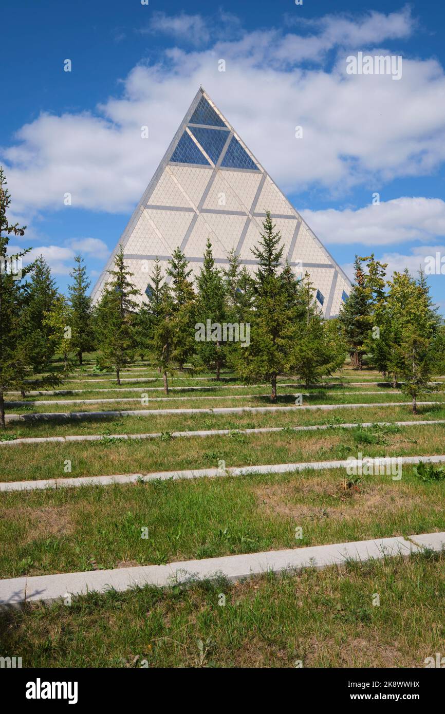 A view of the pyramid with trees and green grass in the foreground. At ...