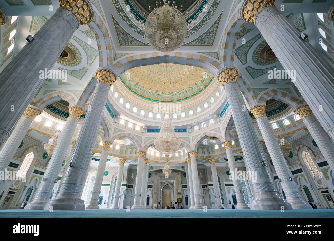 Interior of the richly appointed mosque, with blue-green carpet ...