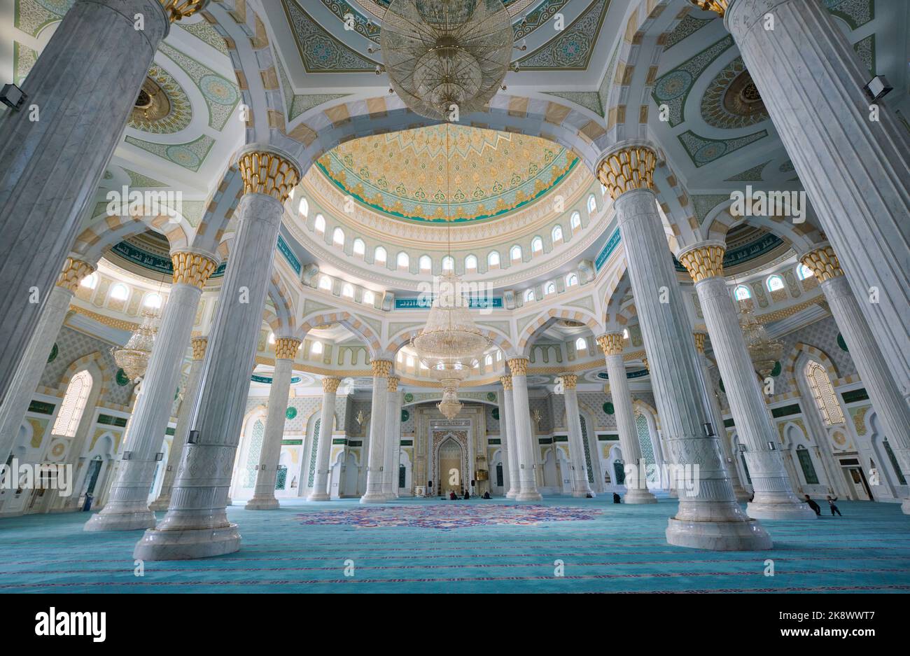 Interior of the richly appointed mosque, with blue-green carpet ...
