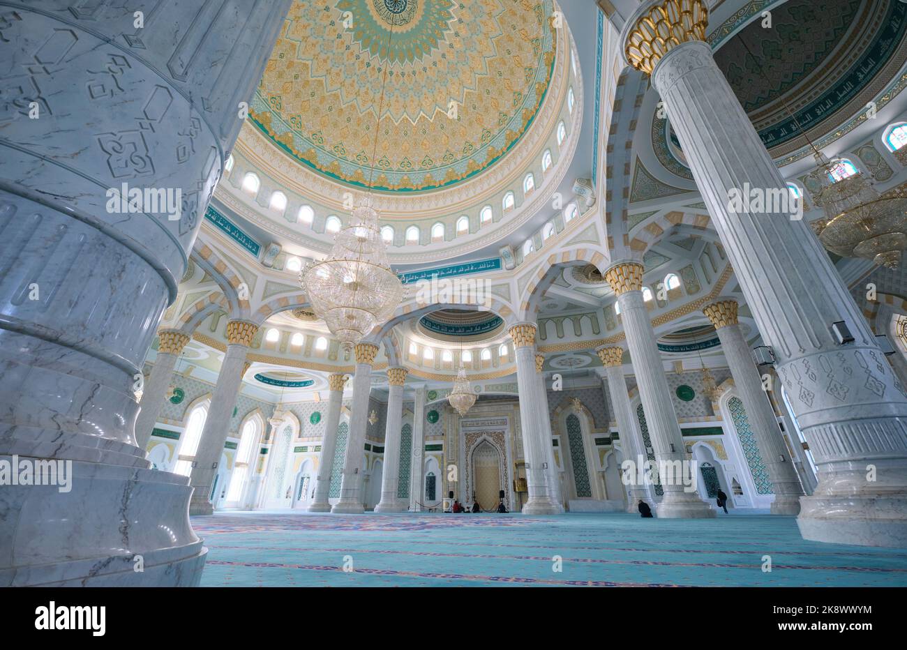 Interior of the richly appointed mosque, with blue-green carpet ...
