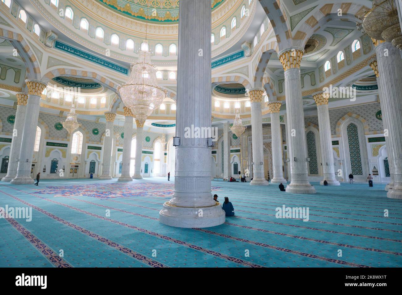 Interior of the richly appointed mosque, with blue-green carpet ...