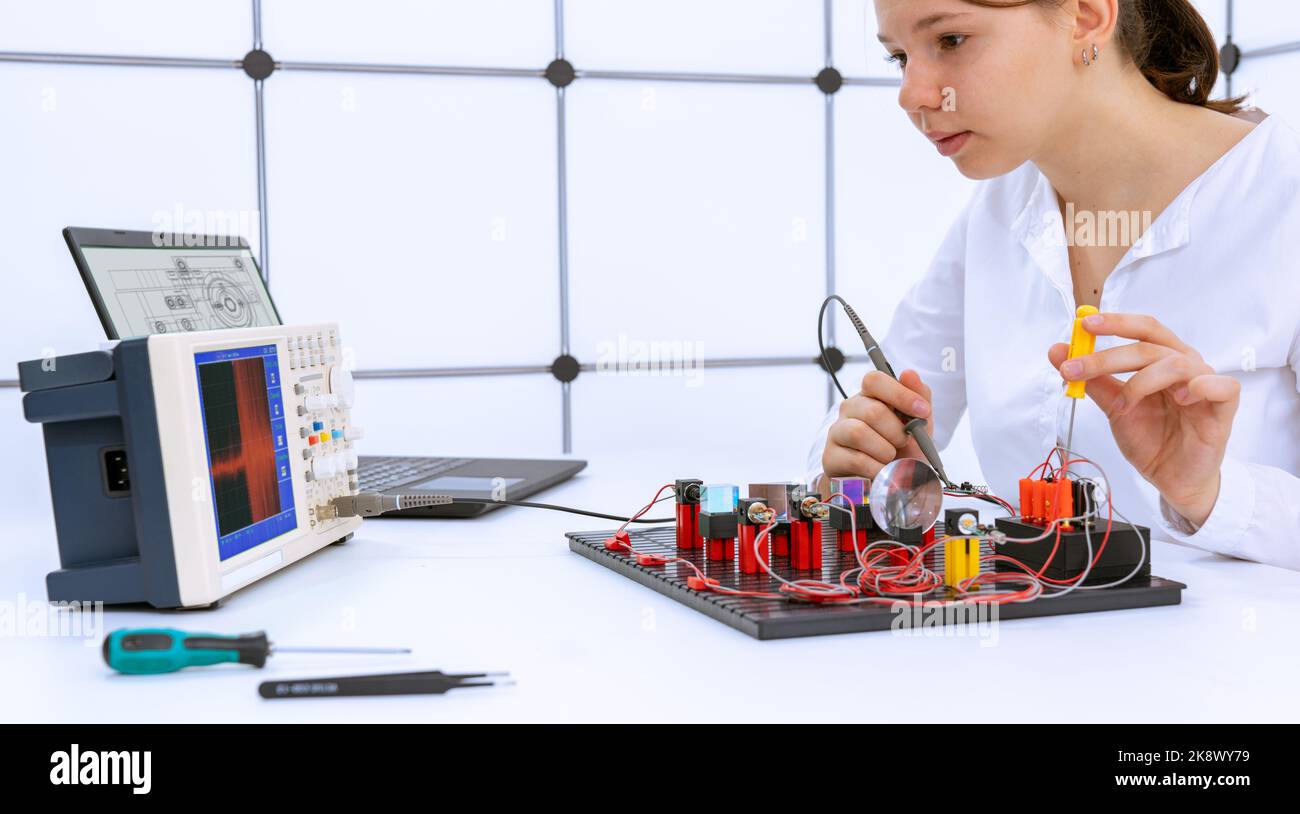 young woman student is experimenting with a laser measurement system ...