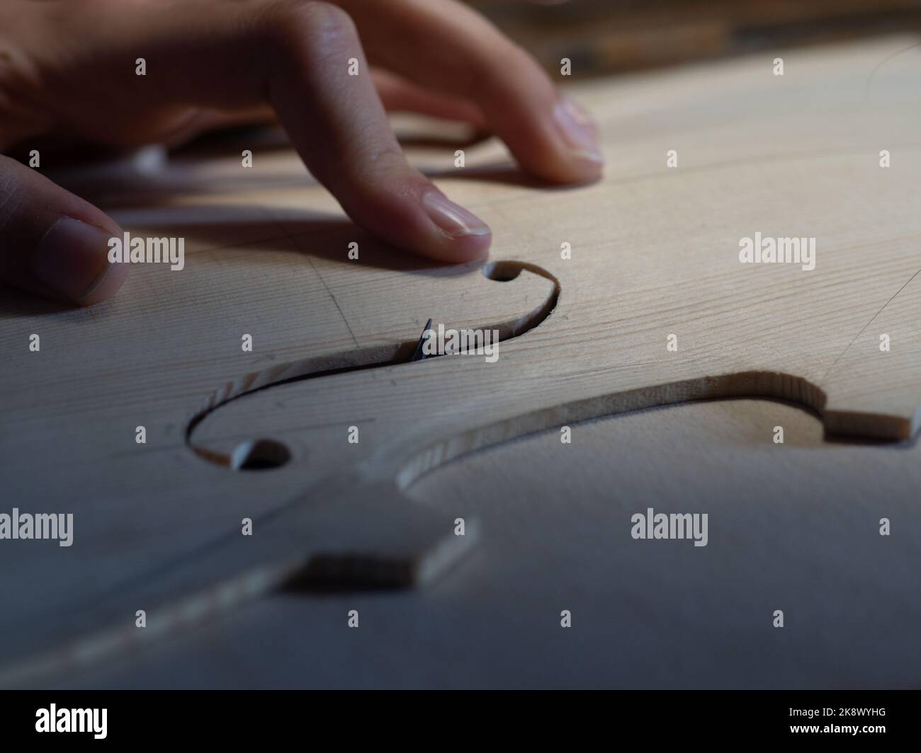 cutting and shaping holes in a violin table Stock Photo - Alamy