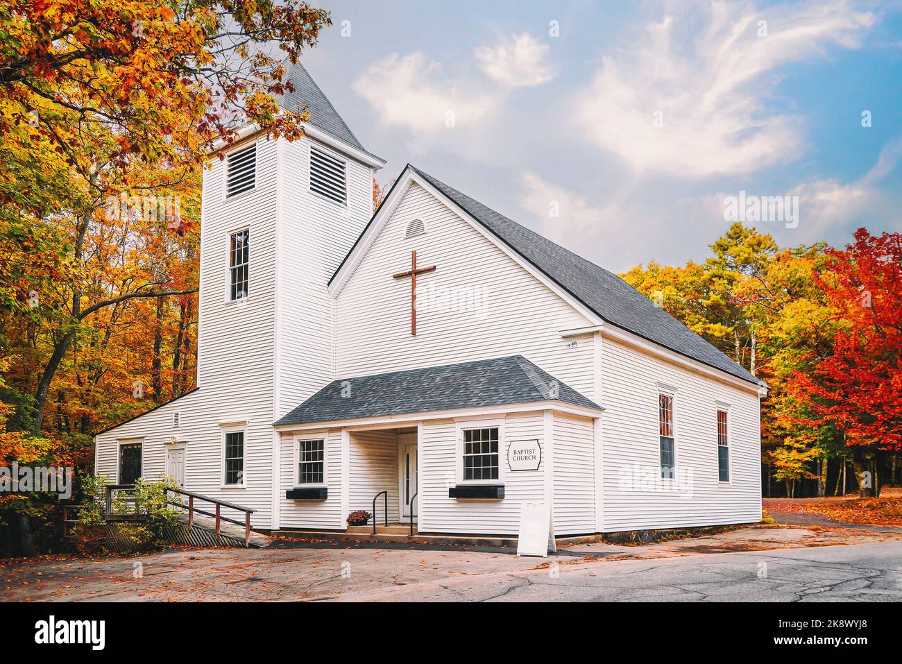 White country Baptist church surrounded by autumn colors in New England ...