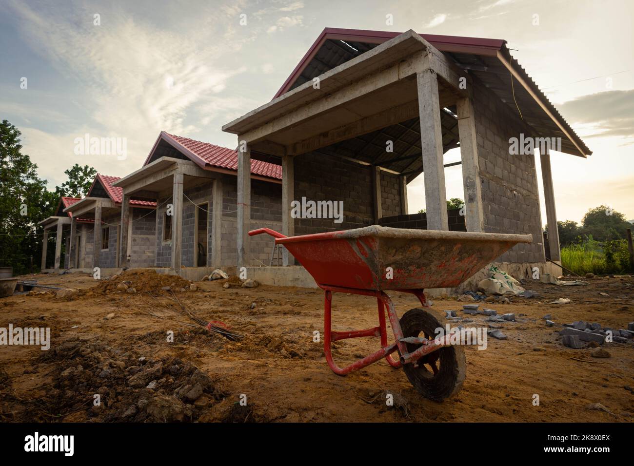 Red steel soil cart at the construction site. Home building on progress ...
