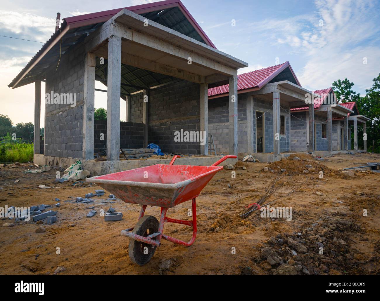 Red steel soil cart at the construction site. Home building on progress ...