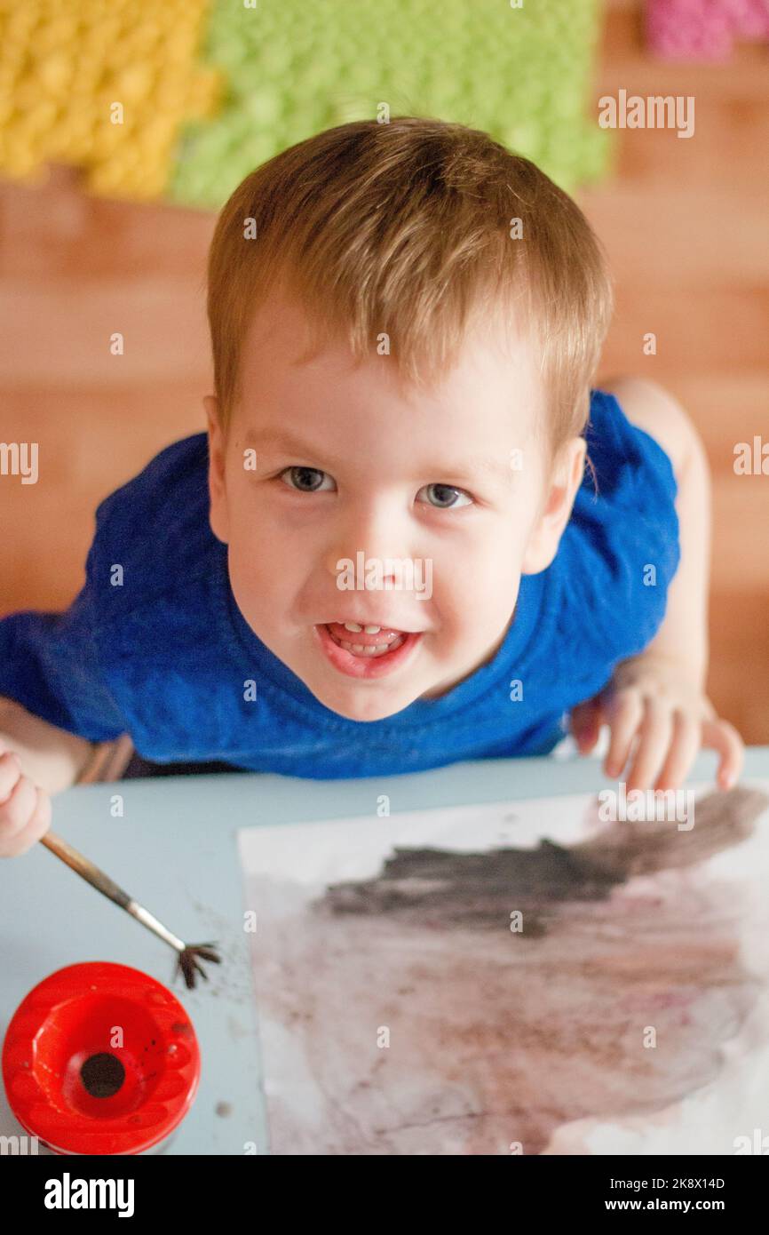 portrait of a boy with blond hair, painting a picture. Early childbirth ...