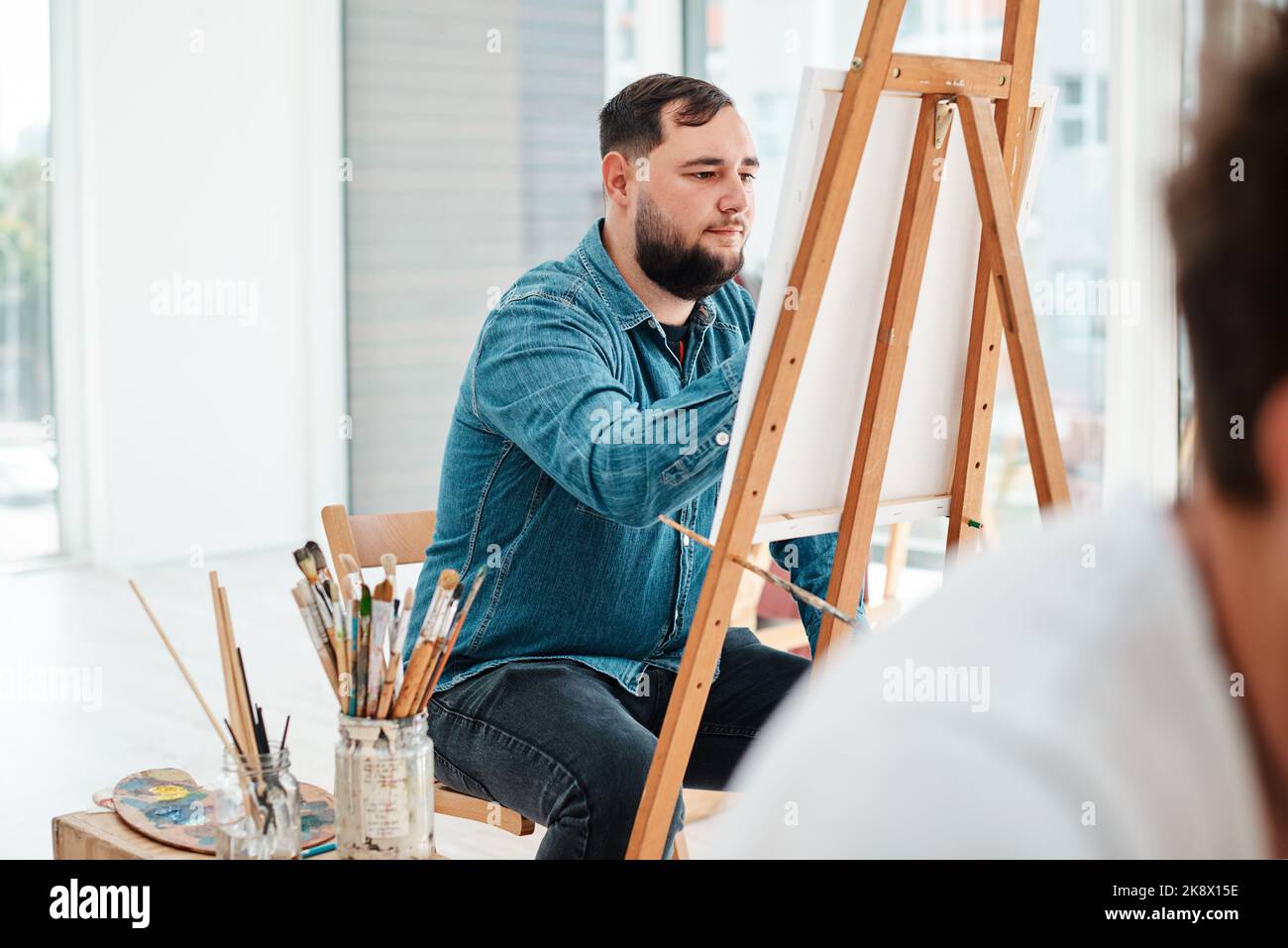 I can be creative through art. a handsome young artist sitting and ...