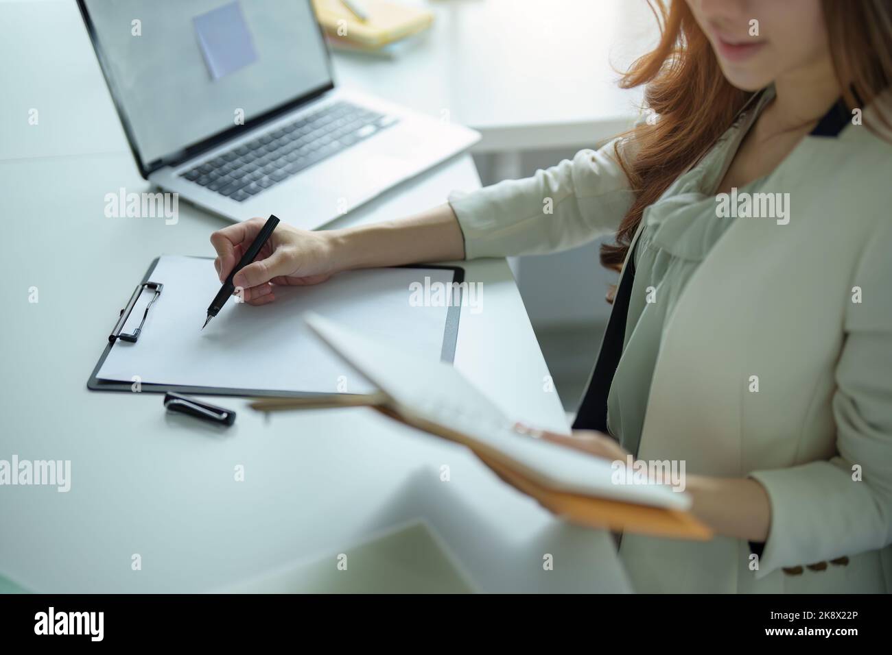 Portrait of an Asian bank employee using notebooks to take notes ... Portrait of an Asian bank employee using notebooks to take notes ...