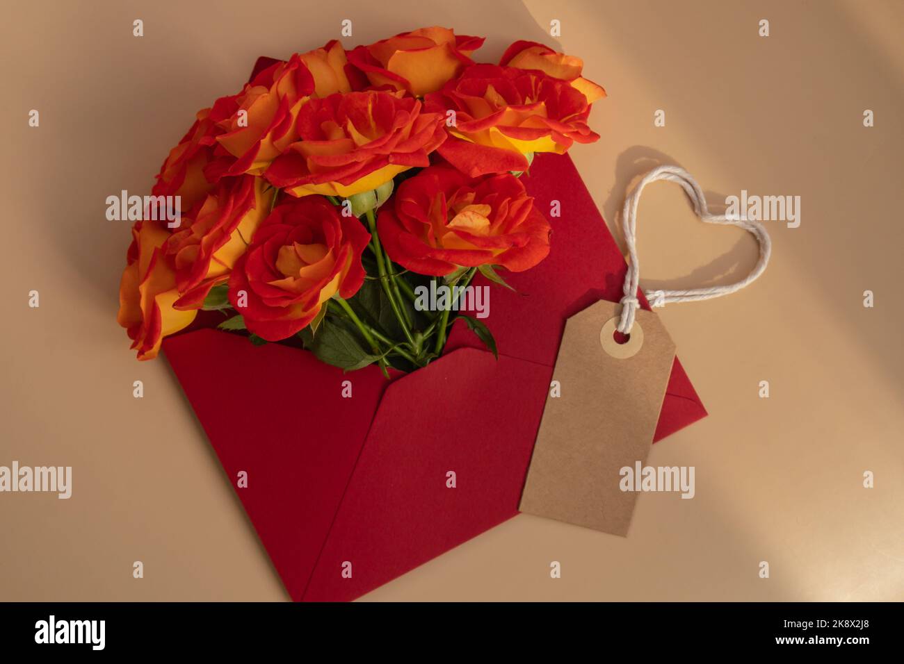 Beautiful red roses flowers in postal red envelope on red background ...