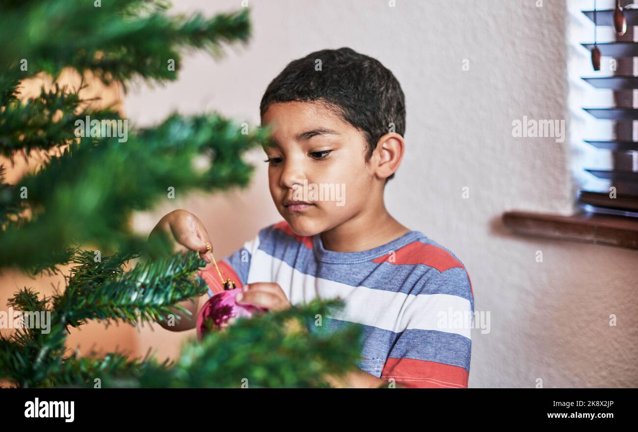 Setting up for Christmas. a carefree little boy putting up Christmas ...