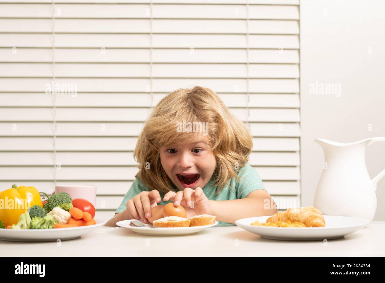 Portrait of preteen child eat fresh healthy food in kitchen at home ...