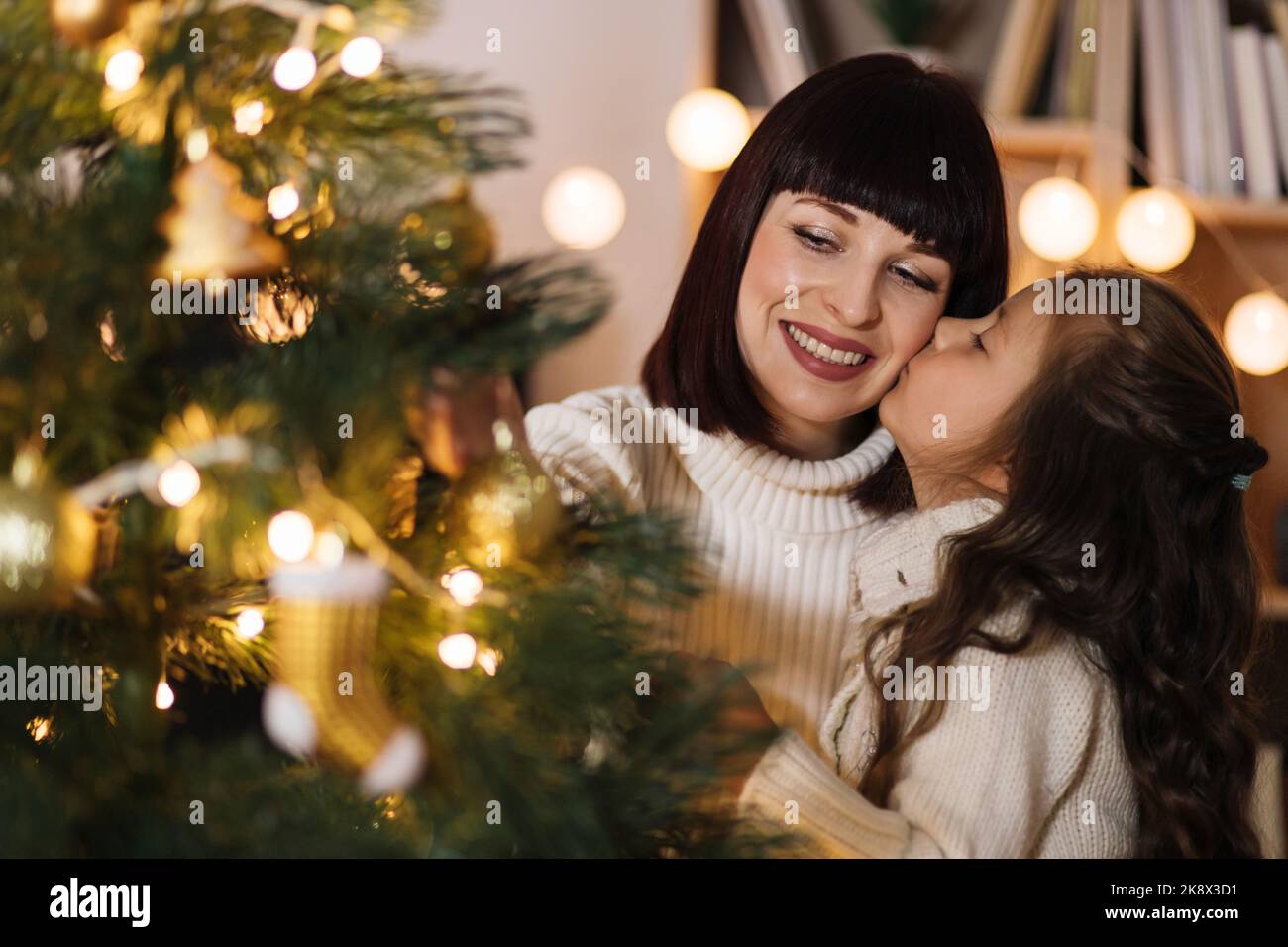 Happy small preschool caucasian child girl decorating Christmas tree ...