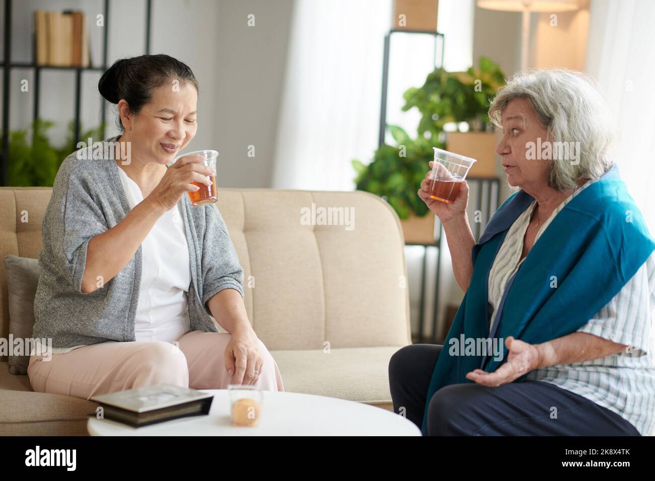 Senior female best friend having emotional conversation when drinking ...