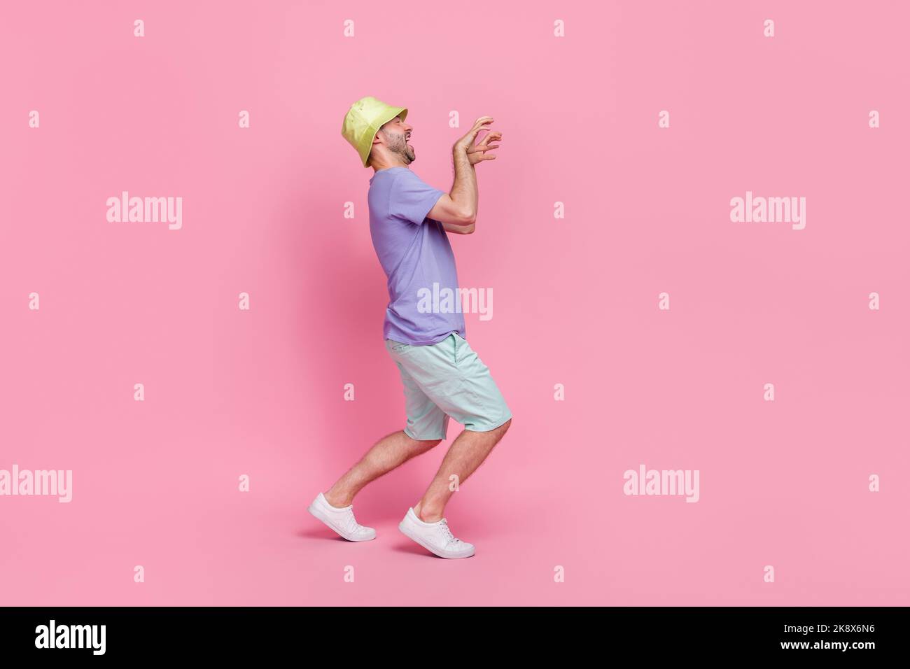 Full body photo of nice young man pretending dinosaur predator roar ...