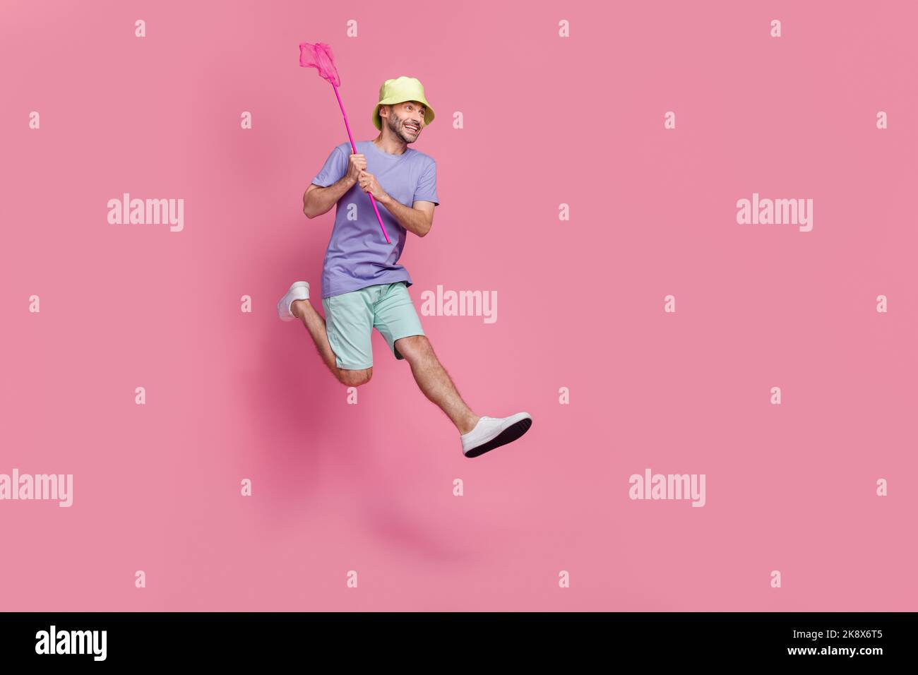 Full size photo of handsome young man jumping holding butterfly net ...