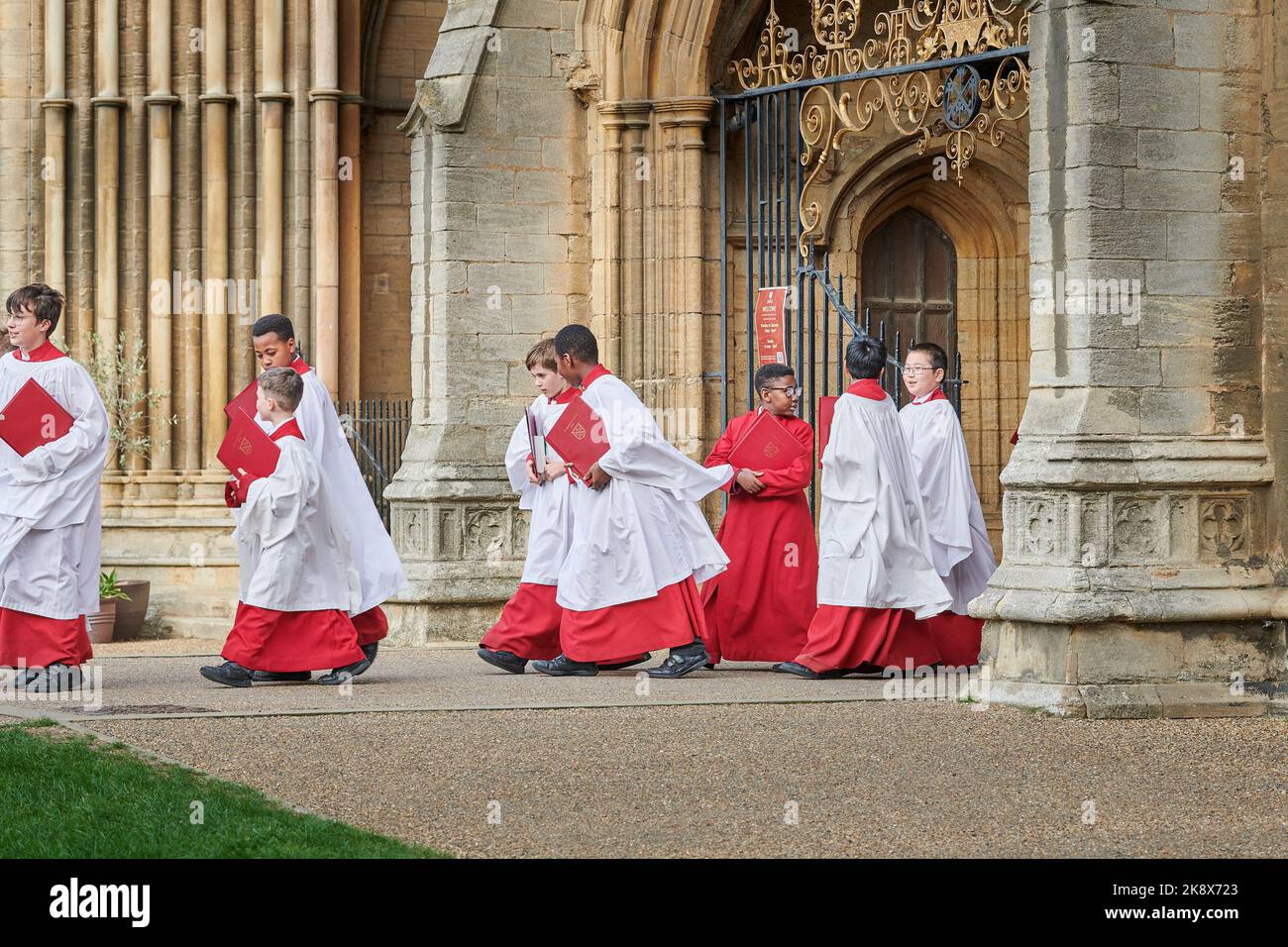 A group of choir boys leaves the west door at the medieval christian ...