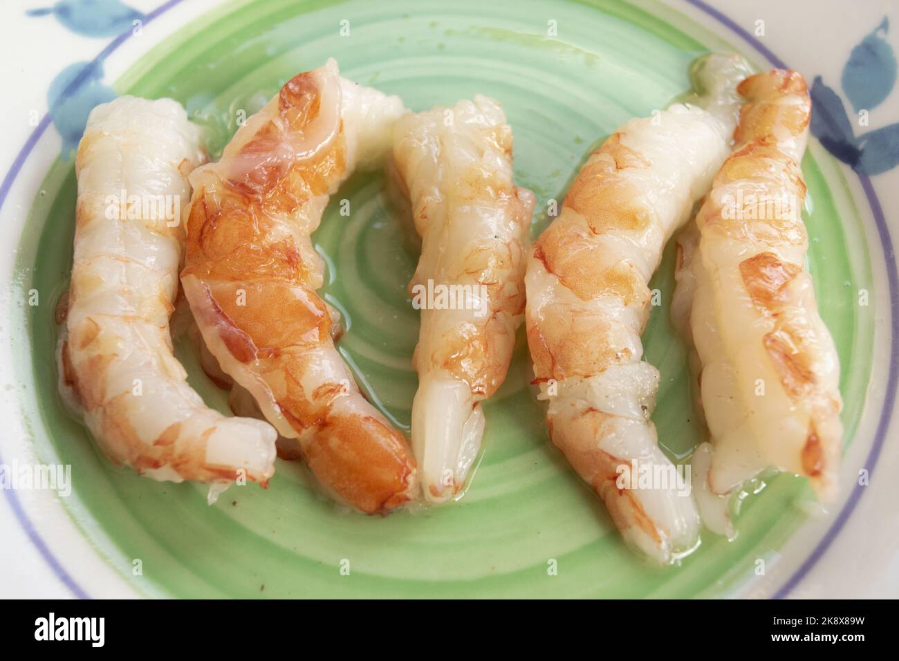 raw shrimps peeled and arranged in a row on a plate Stock Photo - Alamy