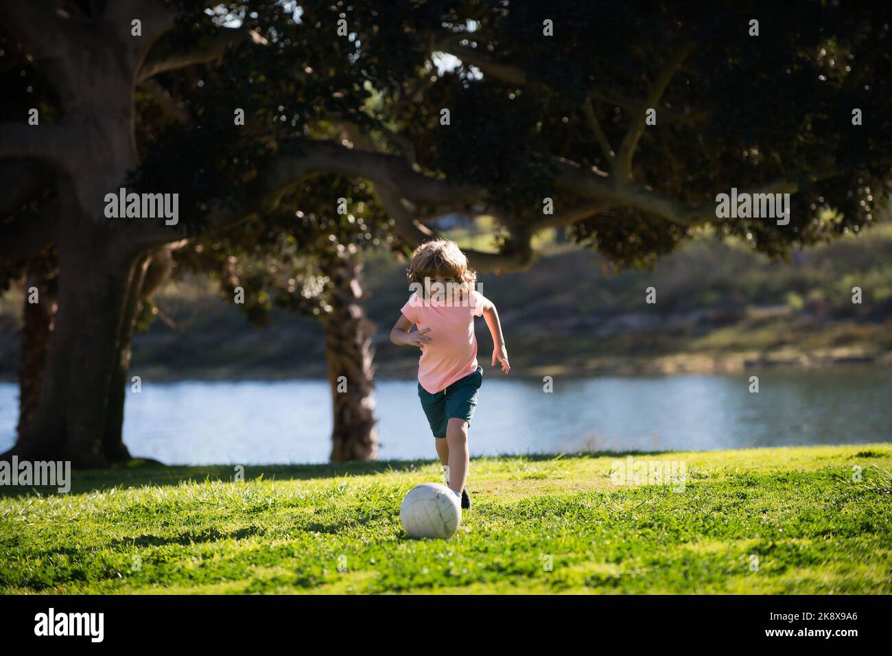 Soccer kid. Kids play football on outdoor stadium field. Little boy ...