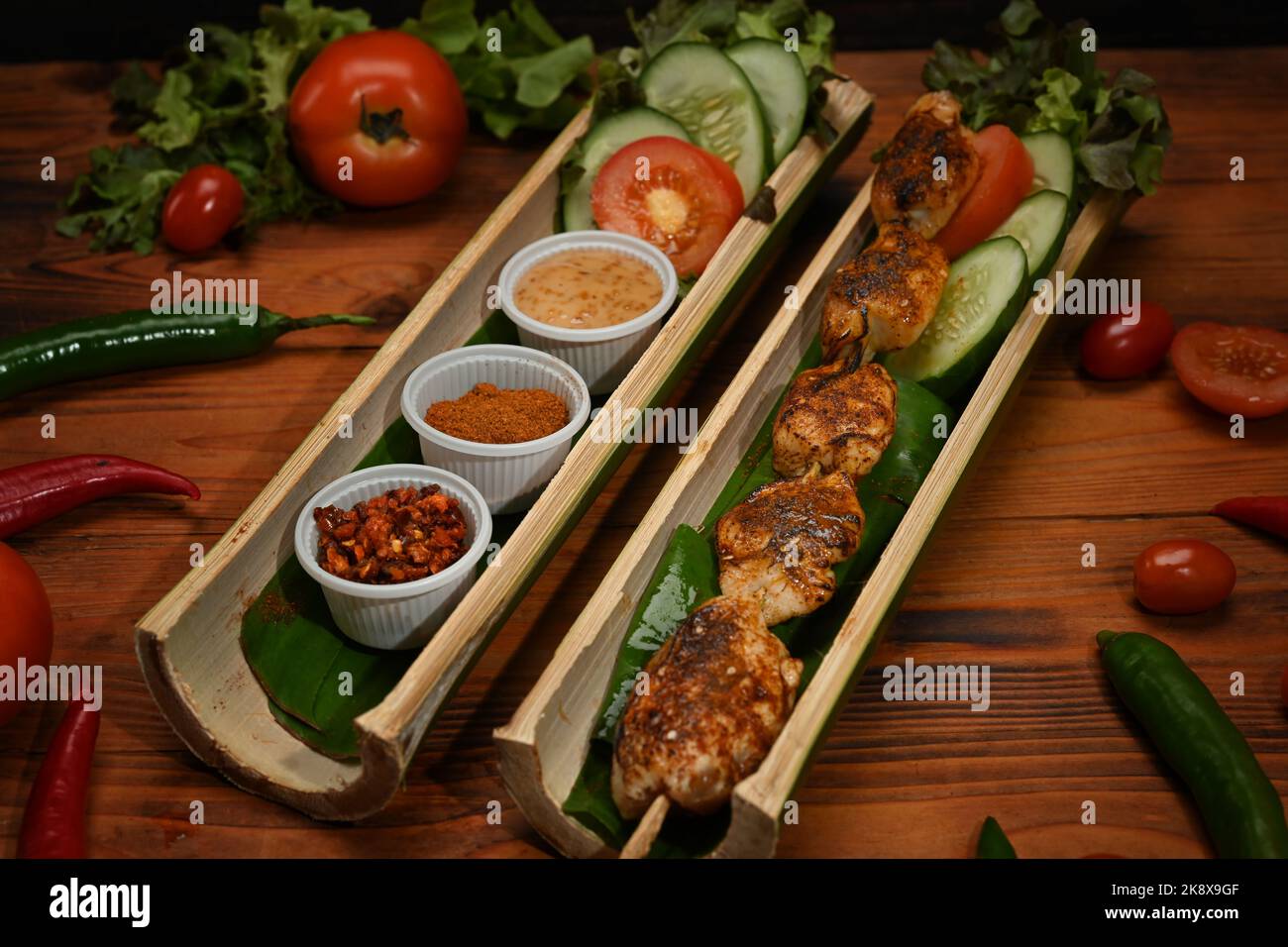 Grilled chicken meat skewer in bamboo barrel plant with Sichuan pepper, Chinese spices and ...