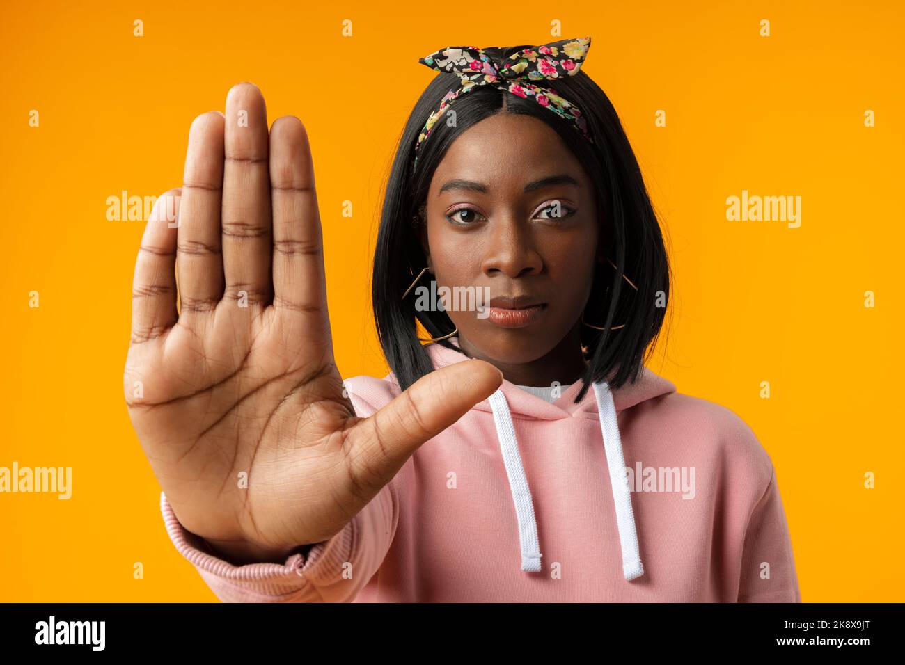 Young african woman over yellow background doing stop sign with palm of ...