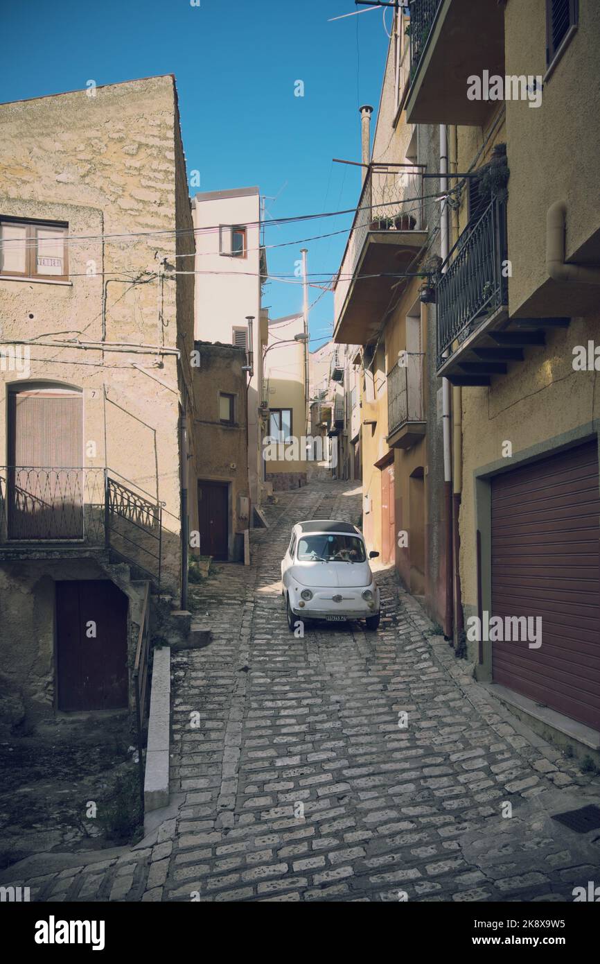 old car Fiat 500 in a narrow street of Prizzi village in Western Sicily ...