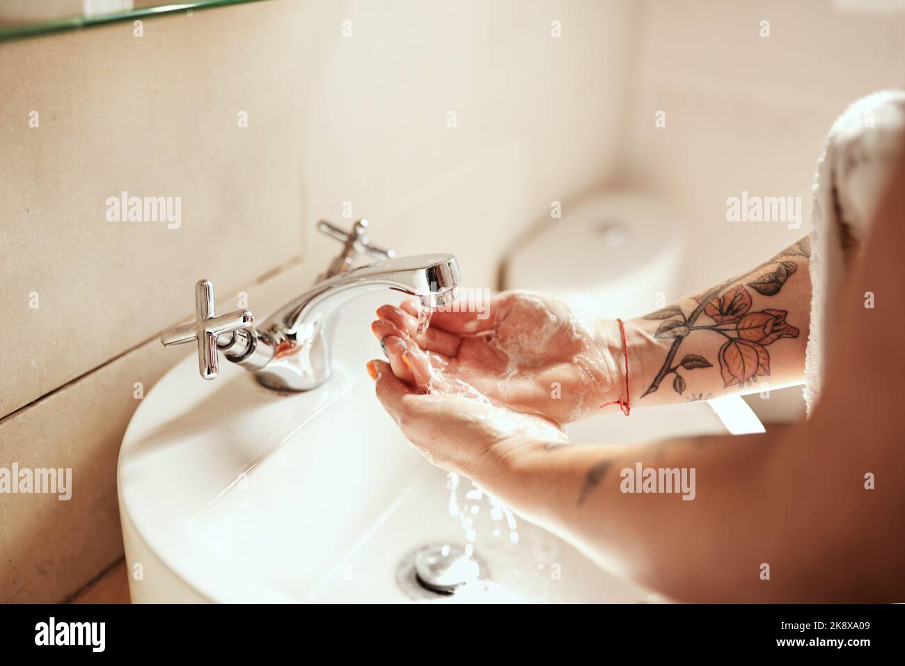 Good habits good health. a woman washing her hands at the bathroom sink ...