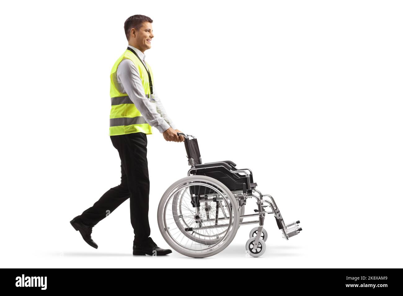 Airport worker pushing an empty wheelchair isolated on white background ...