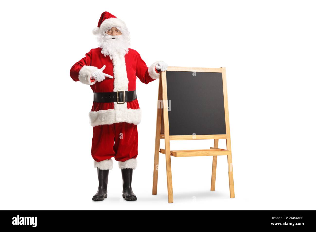 Santa claus standing next to blackboard with a wooden frame and ...